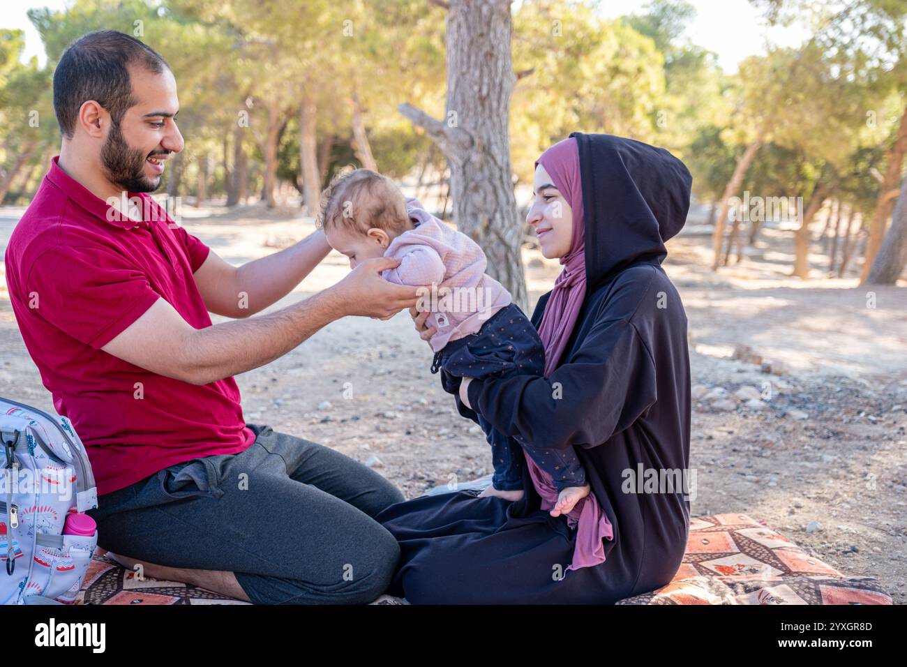 A joyful family moment featuring parents playing with their child in a ...
