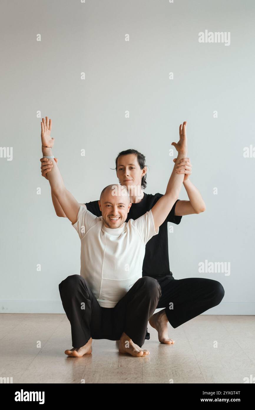 two young athletes practice yoga in the gym. Joint training, indoors ...