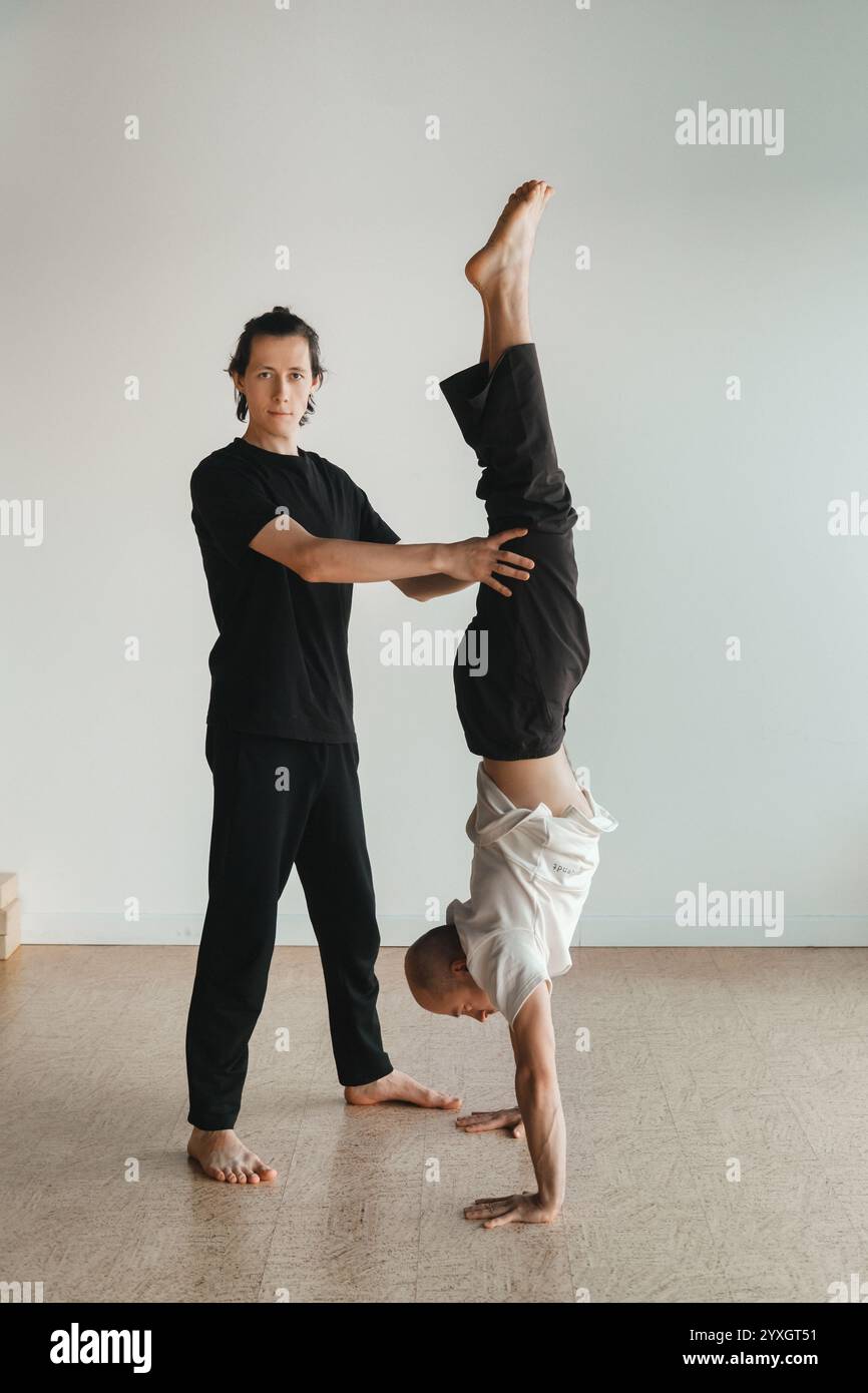 two young athletes practice yoga in the gym. Joint training, indoors ...