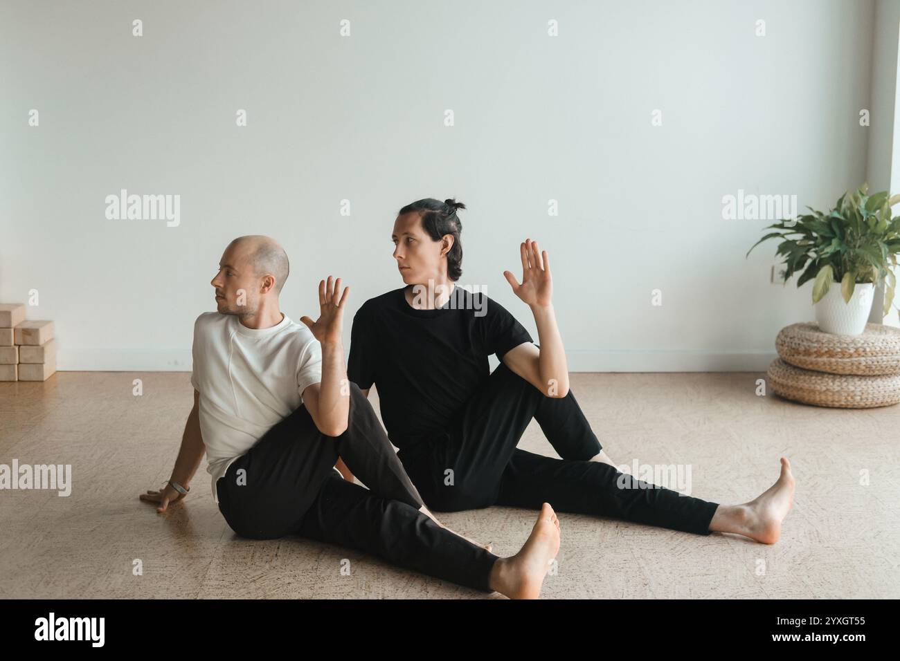 two young athletes practice yoga in the gym. Joint training, indoors ...