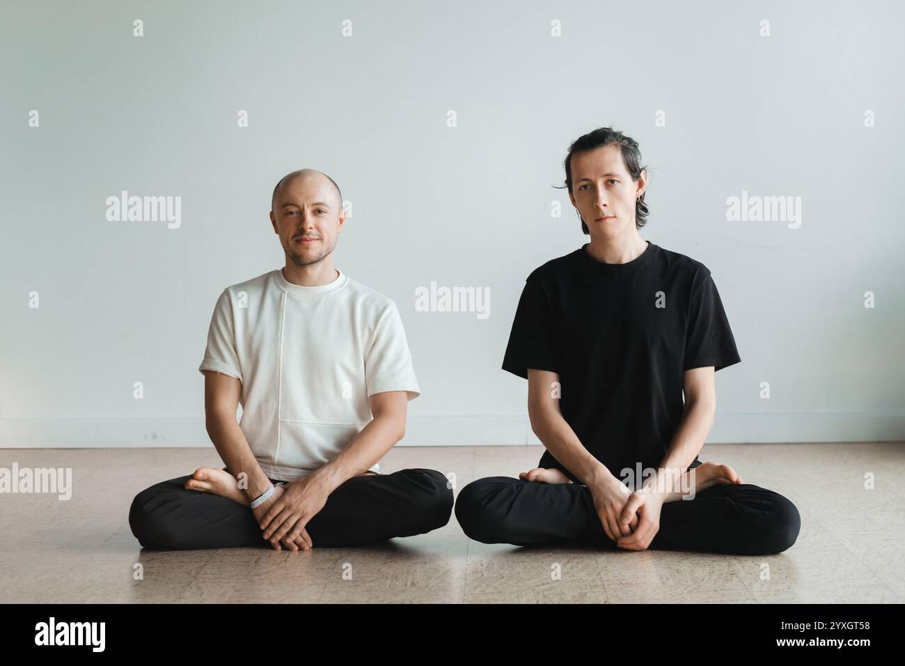 two young athletes practice yoga in the gym. Joint training, indoors ...
