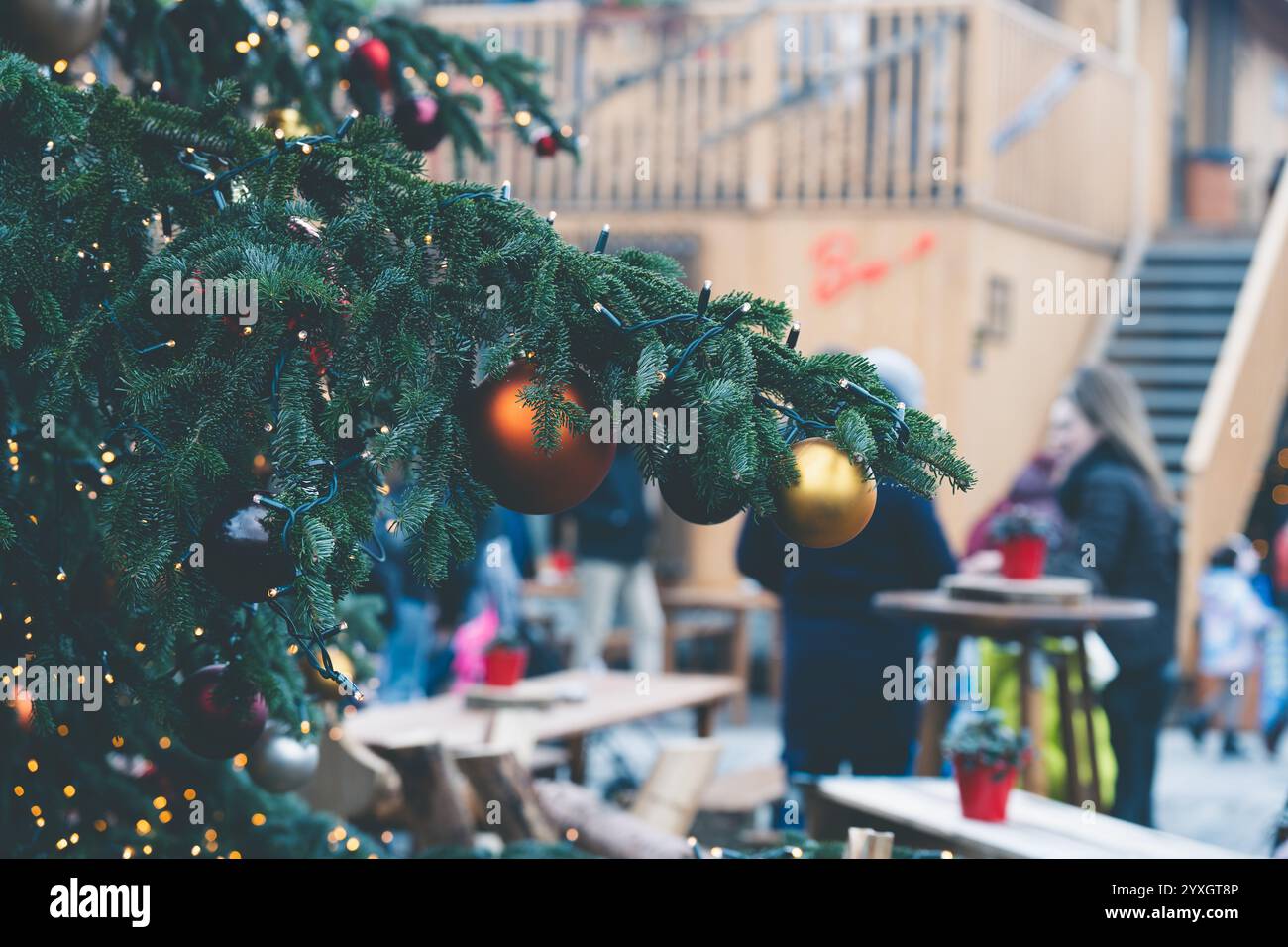 Christmas ornaments on a tree, with defocused Christmas market at the ...