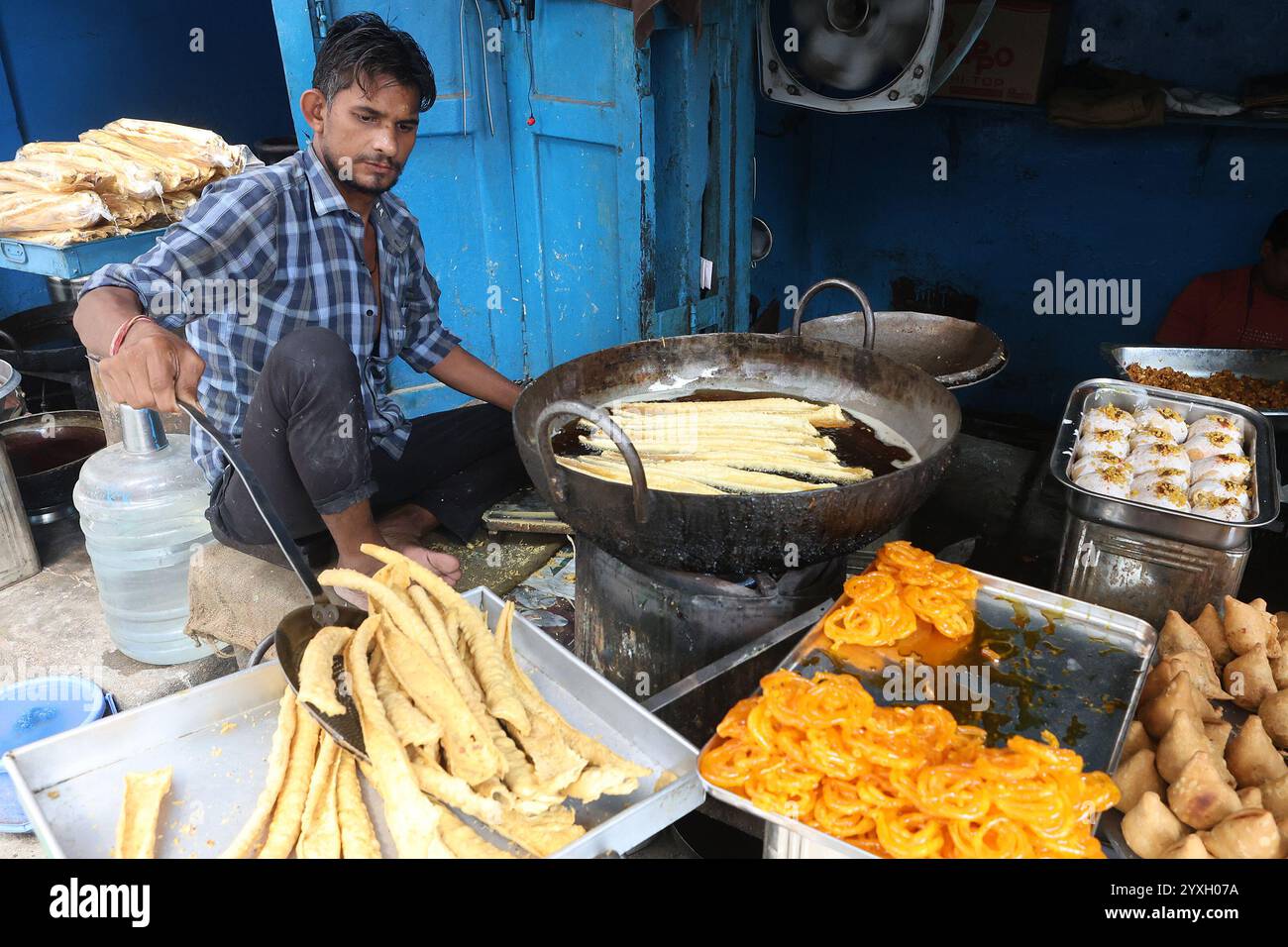 Vendor making ribbon pakoda at a food stall in the George Town district ...