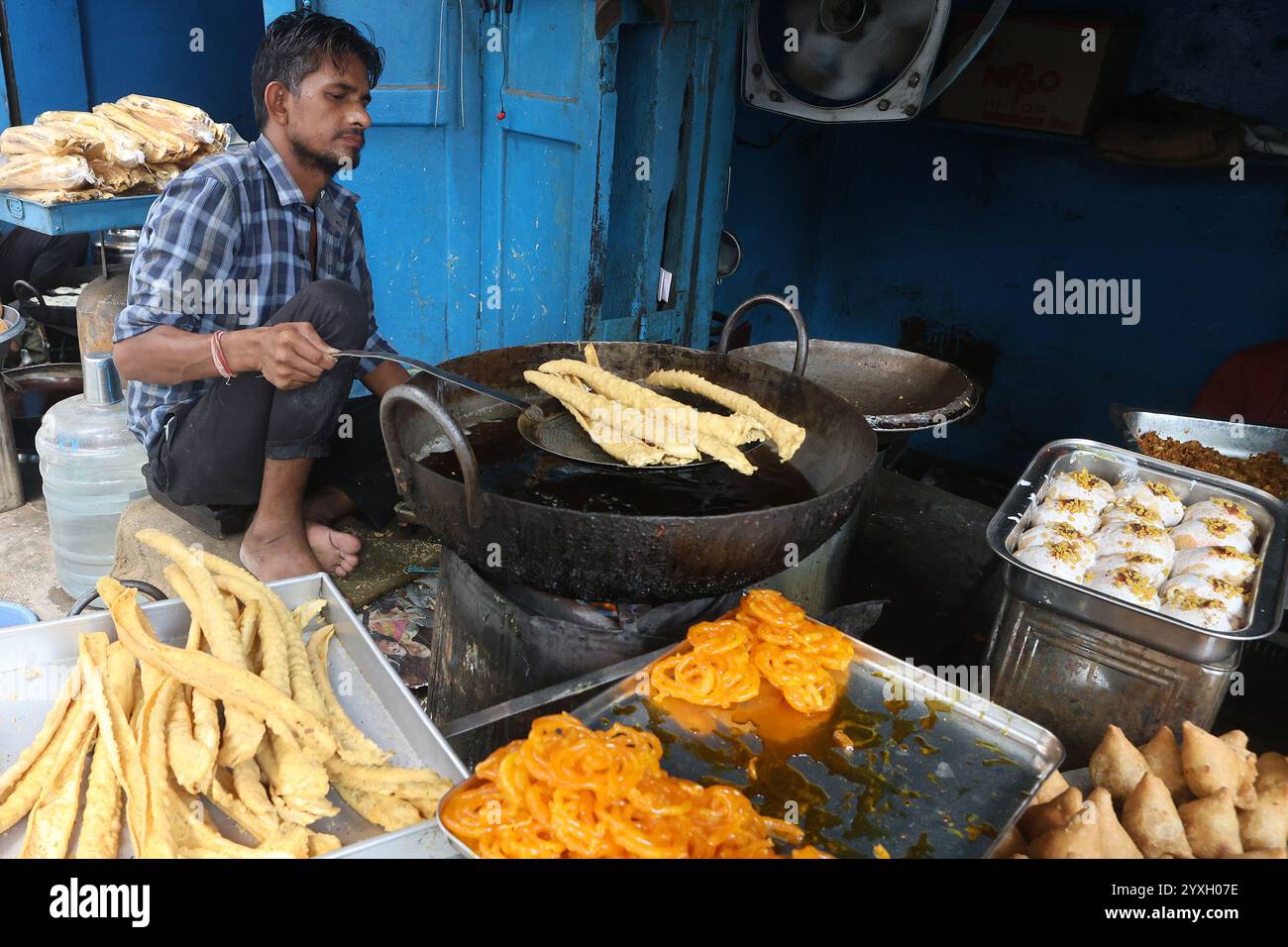 Vendor making ribbon pakoda at a food stall in the George Town district ...