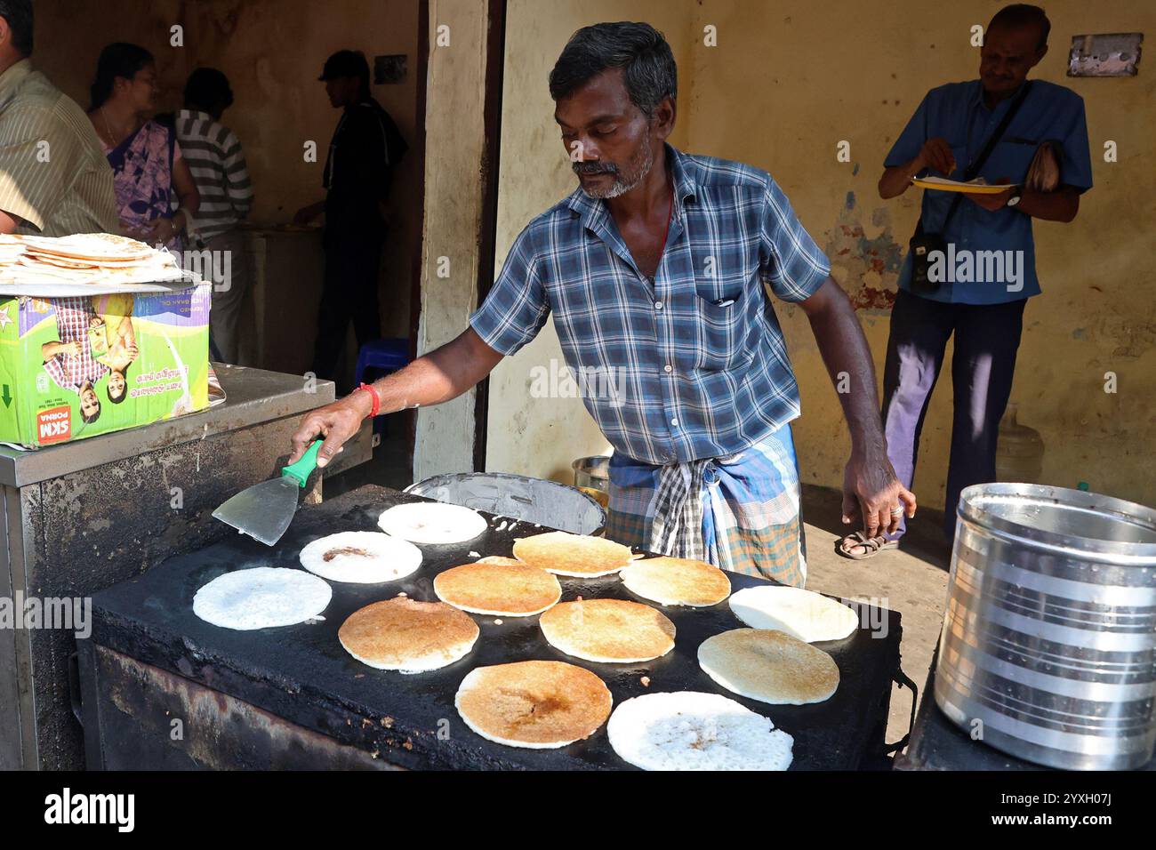 Vendor making dosa at a food stall in the George Town district of ...