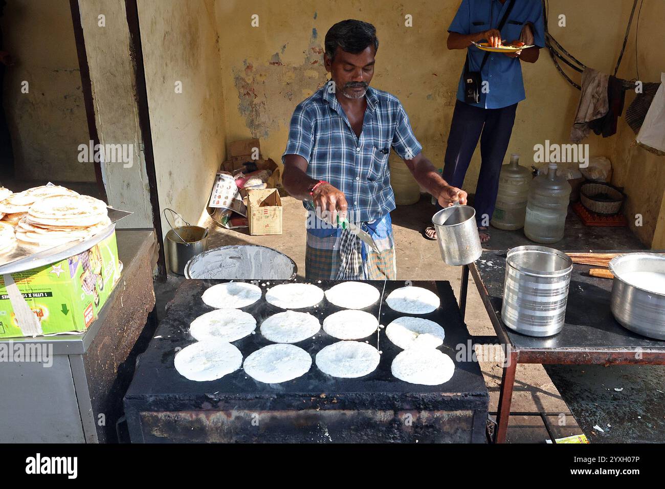 Vendor making dosa at a food stall in the George Town district of ...