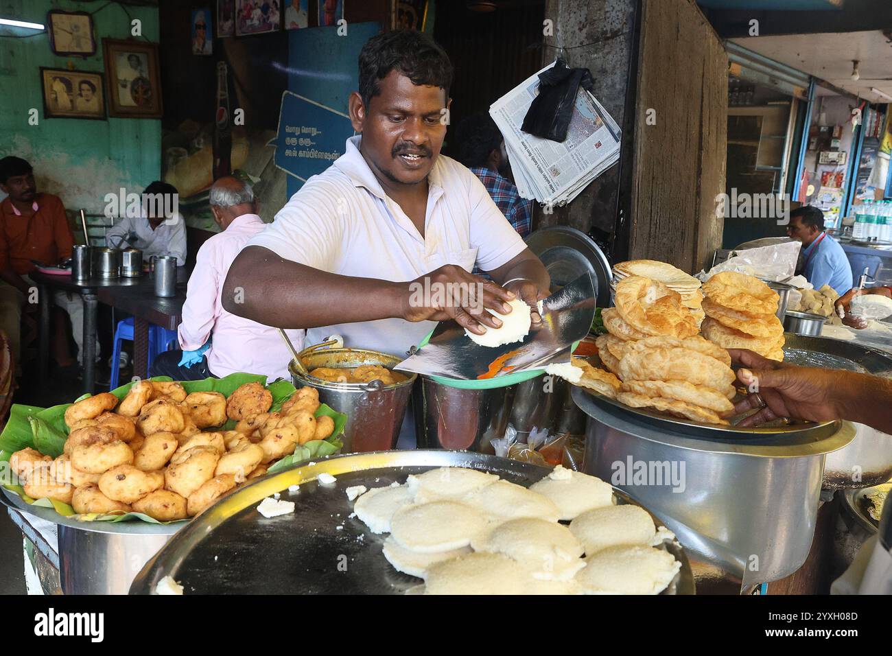Vendor serving idli at a food stall in the George Town district of ...