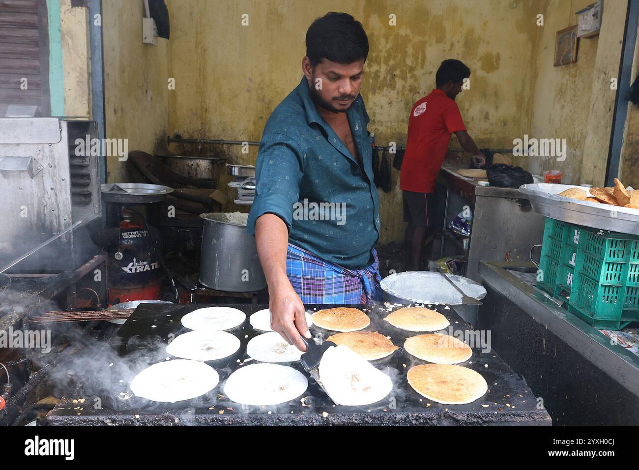 Vendor making dosa at a food stall in the George Town district of ...