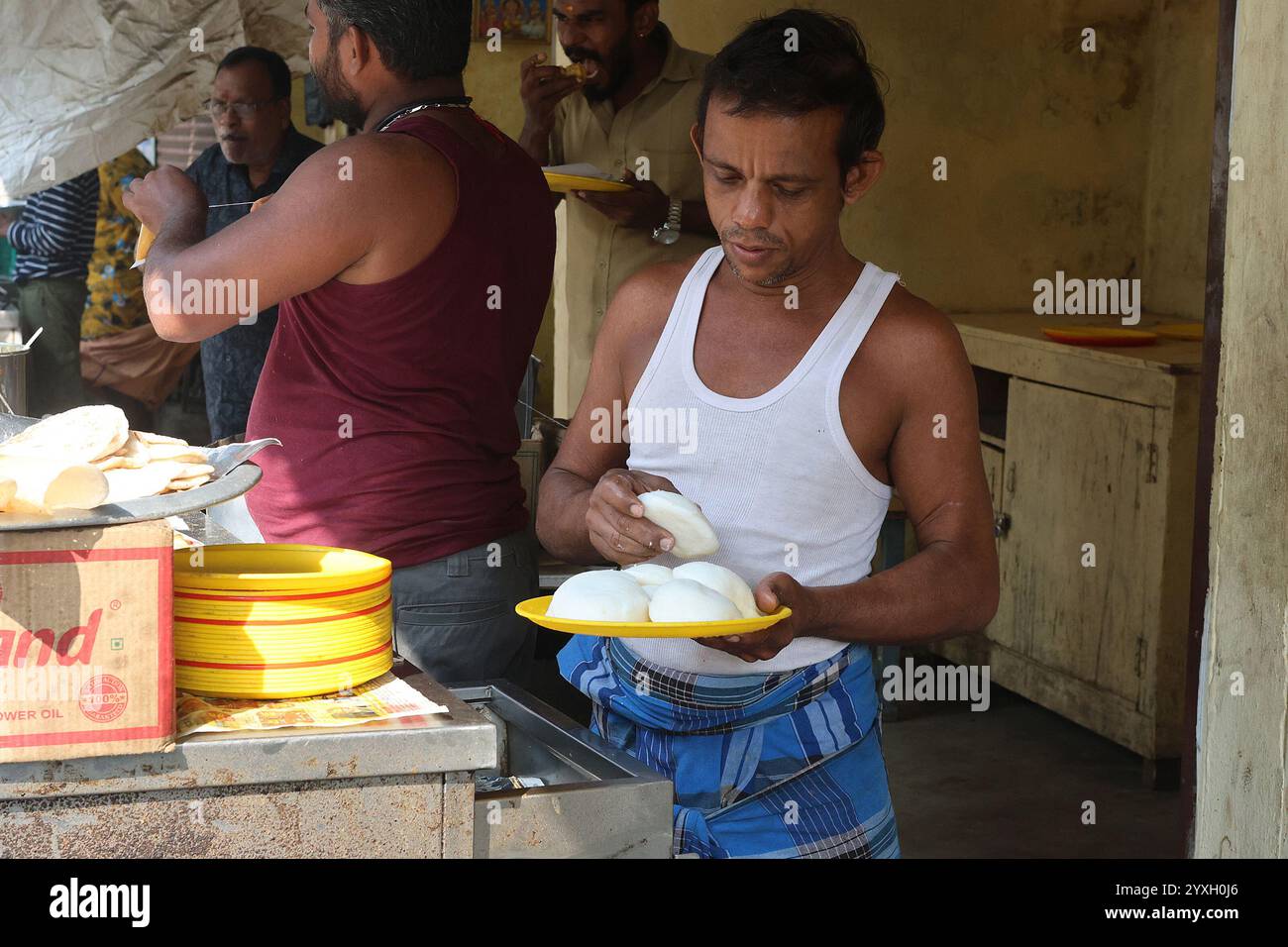 Vendor serving idli from a food stall in the George Town district of ...