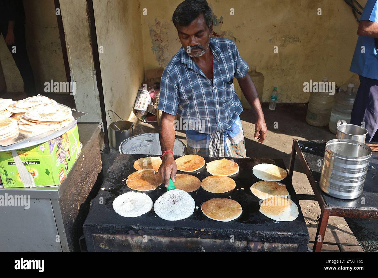 Street vendor cooking dosa at a food stall in the George Town district ...