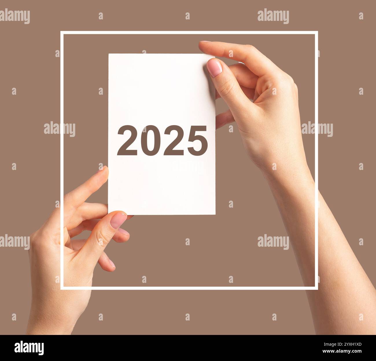 2025 new year, text numbers on paper card in hands on brown mocha ...