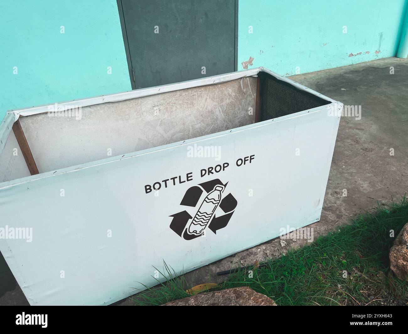 White rectangular collection bin labeled "BOTTLE DROP OFF" with ...