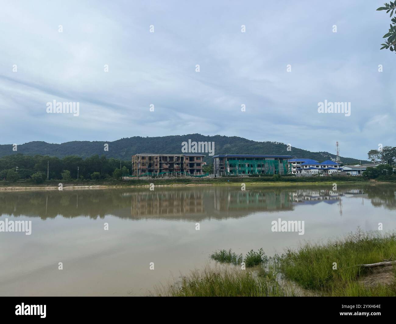 Construction site with partially completed buildings reflected in a ...
