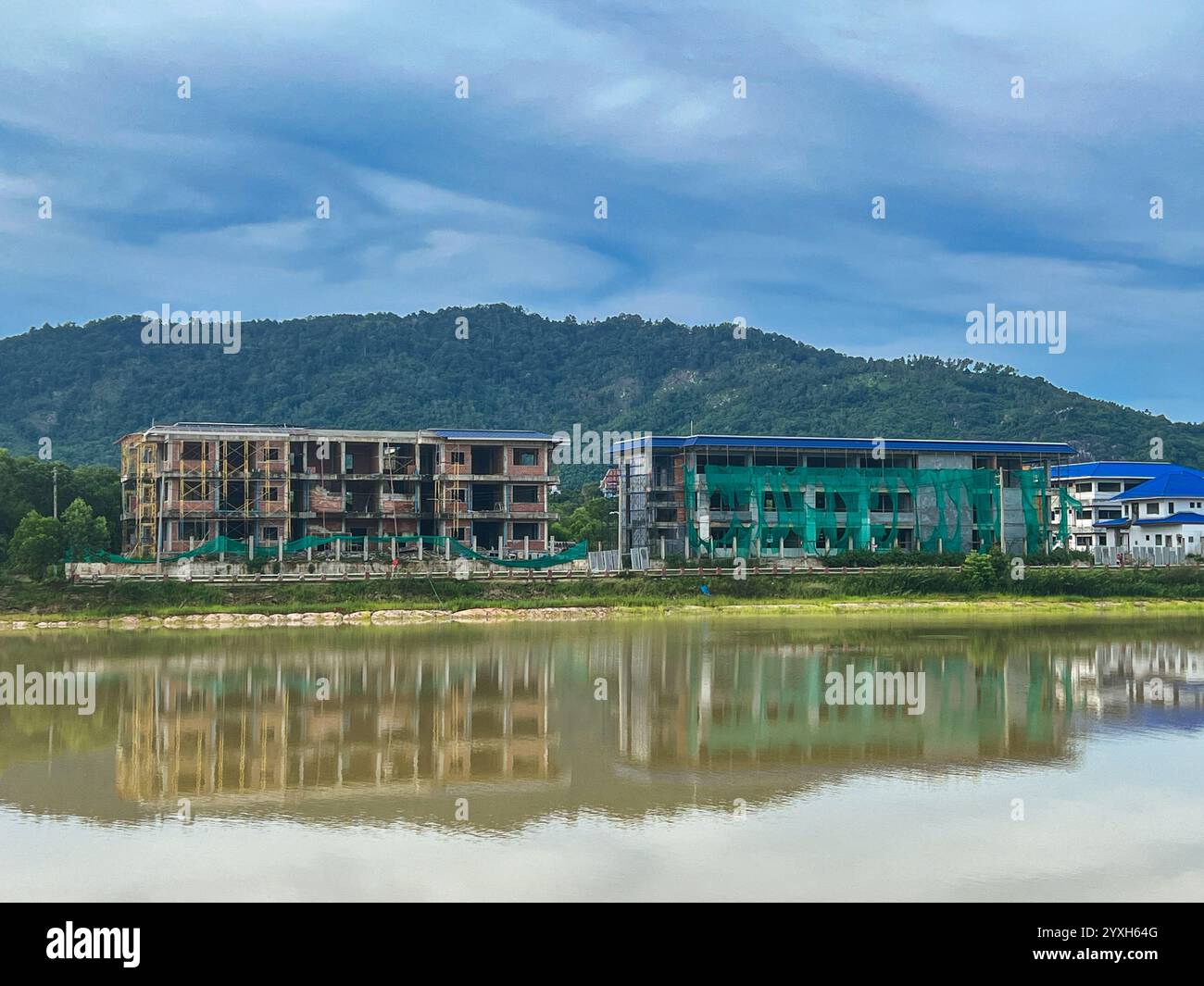 Construction site with partially completed buildings reflected in a ...
