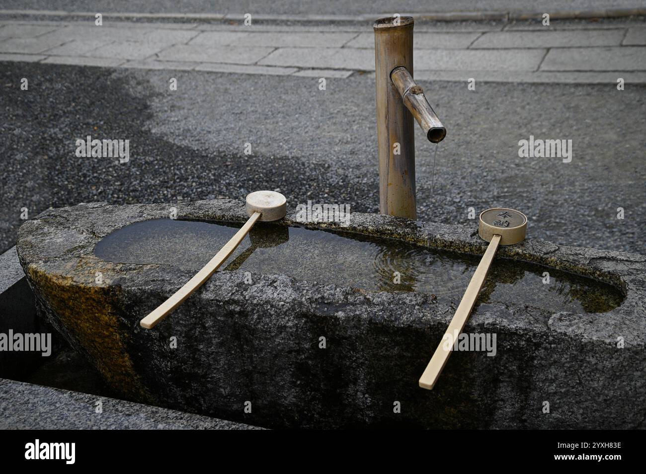 Traditional ancient Japanese Tsukubai stone water basin with bamboo ...