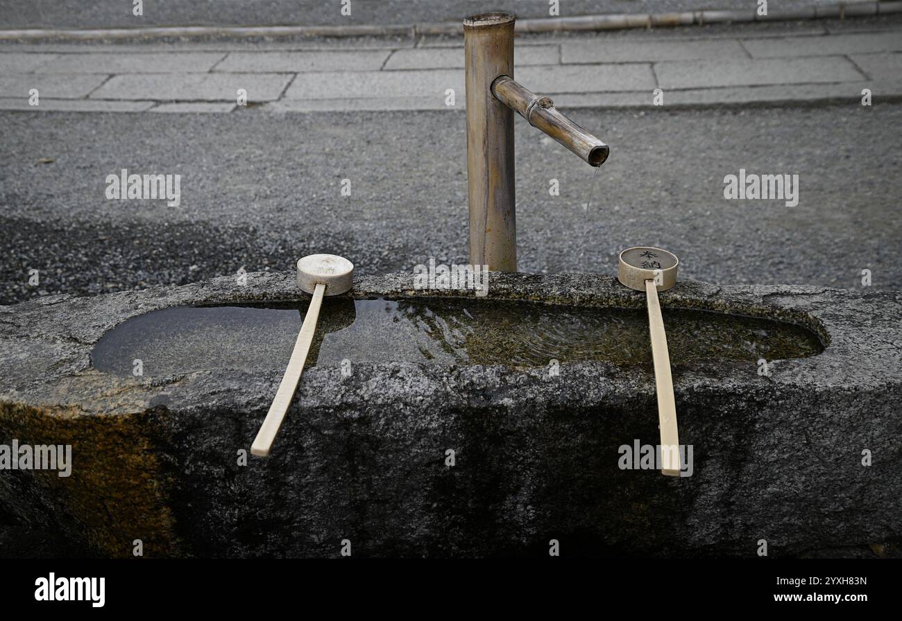 Traditional ancient Japanese Tsukubai stone water basin with bamboo ...