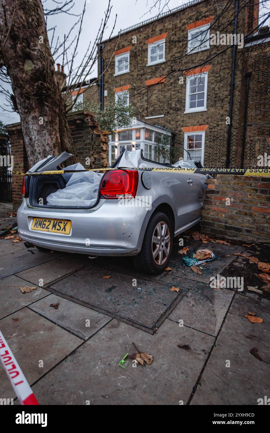 A car's roof is removed and lays wedged in a residential wall following ...
