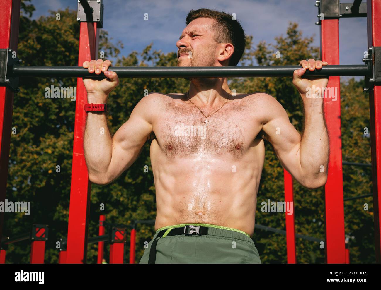 young athlete doing pull-ups on an outdoor sports ground Stock Photo ...
