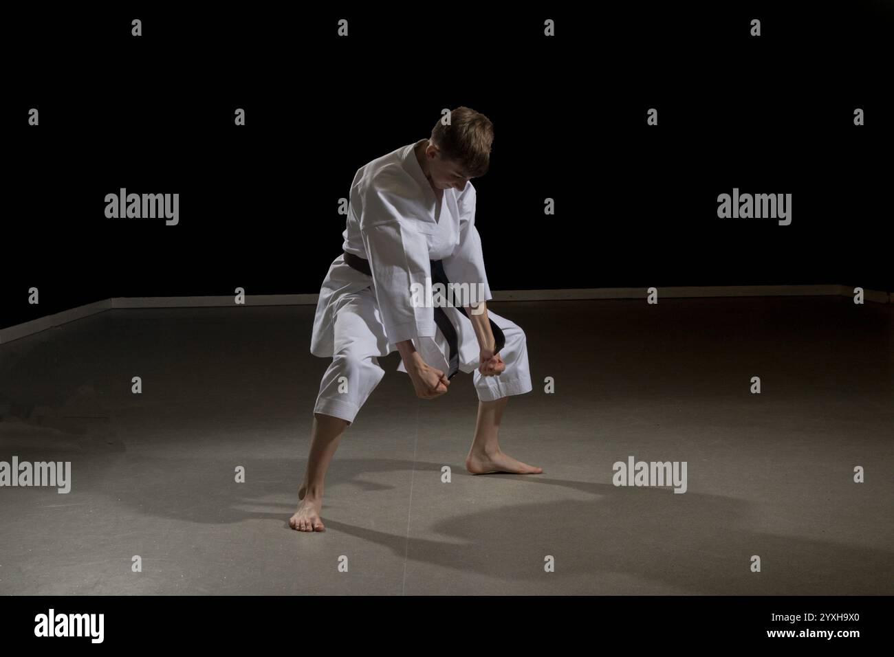 Fifteen year old male teenage karate black belt performing kata Seipai ...