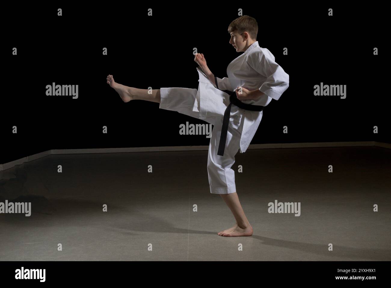 Fifteen year old male teenage karate black belt performing kata Seipai ...