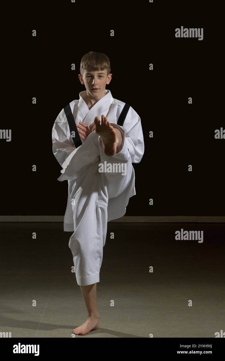 Fifteen year old male teenage karate black belt performing kata ...
