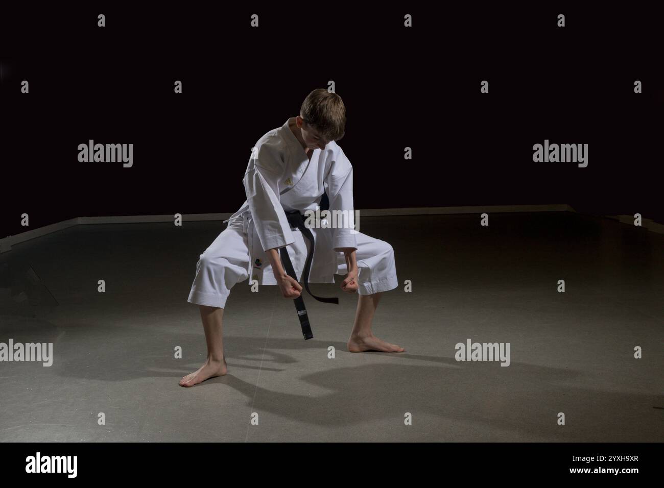 Fifteen year old male teenage karate black belt performing kata Seipai ...