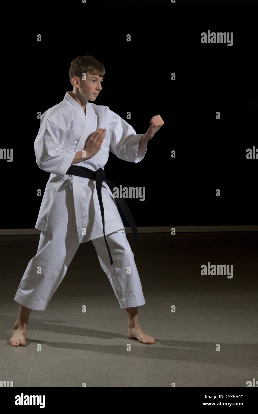 Fifteen year old male teenage karate black belt performing kata ...