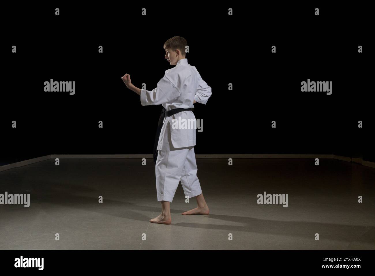 Fifteen year old male teenage karate black belt performing kata ...