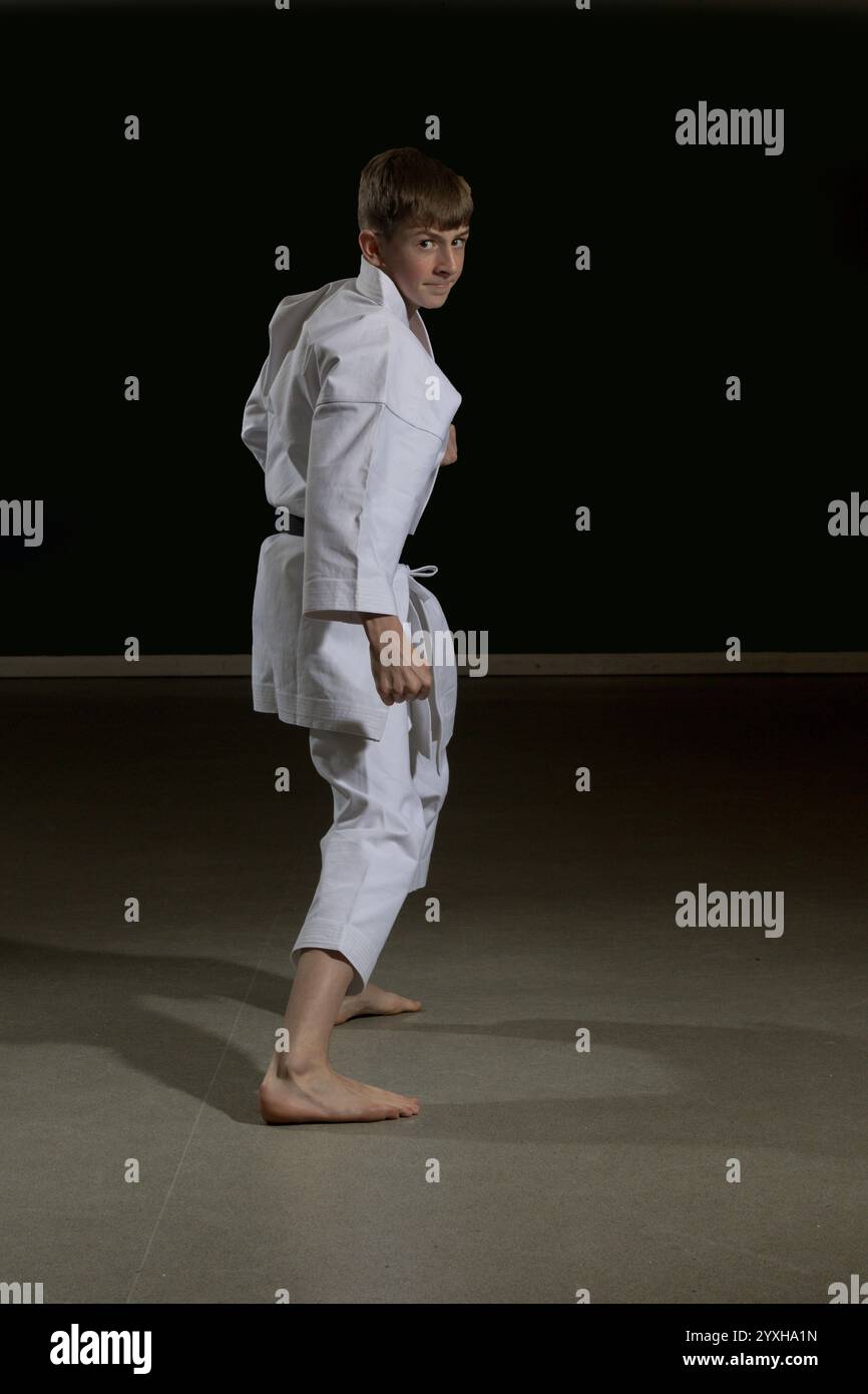 Fifteen year old male teenage karate black belt performing kata Enpi ...