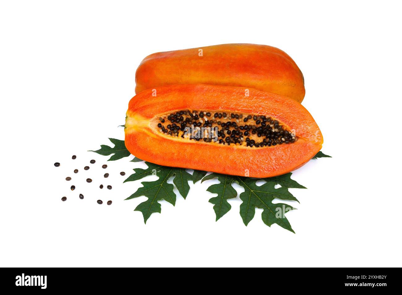 Whole and halved ripe papaya with seeds and green leaf on white ...