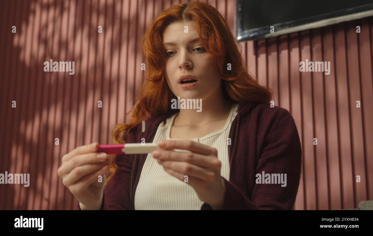 Shocked amazed Caucasian woman at home girl holding pregnancy test ...