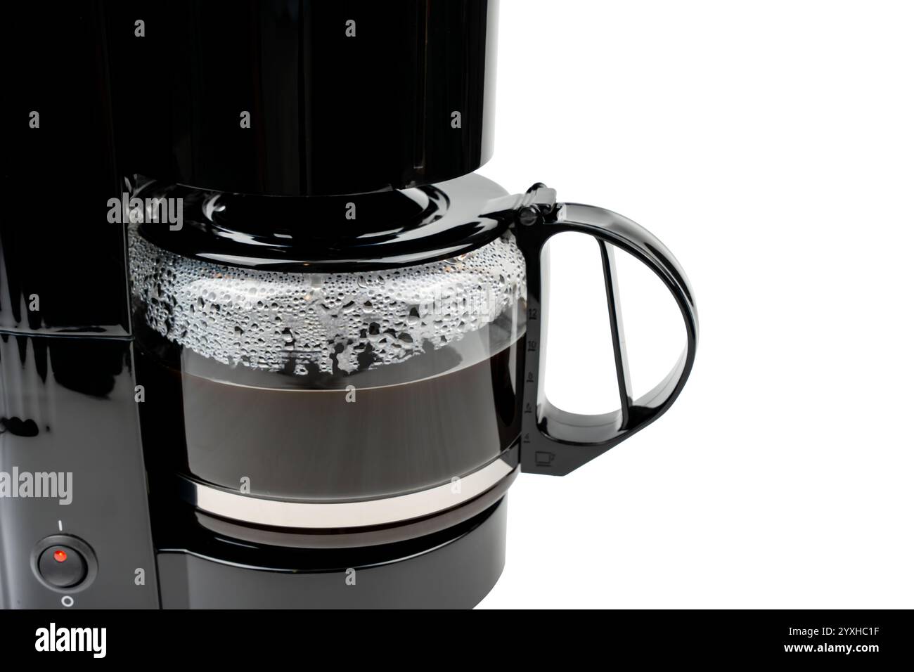 A coffee maker with a glass carafe filled with coffee. The coffee is ...