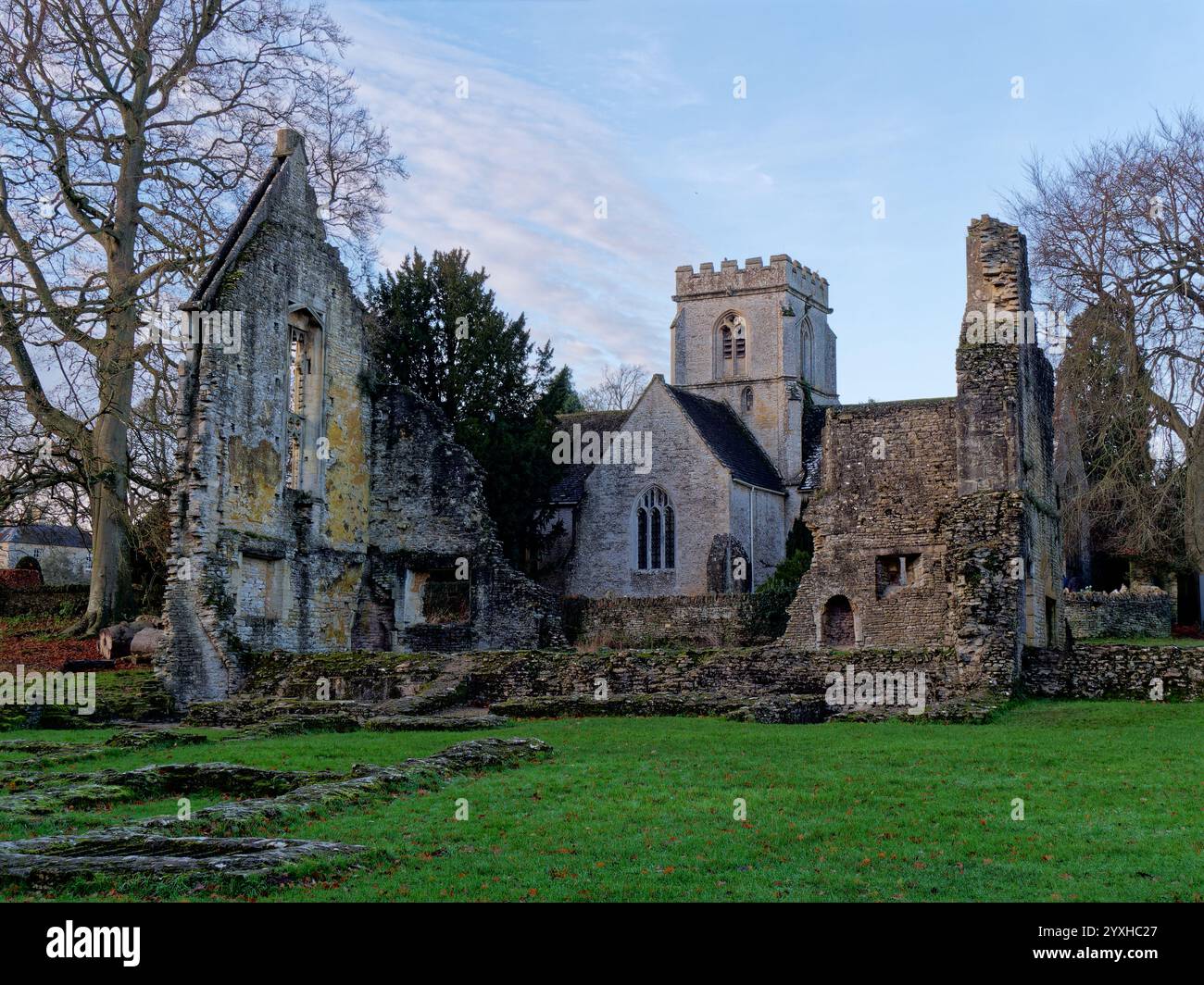 Ruins of Minster Lovell Hall in winter frost with St Kenelm's Church ...