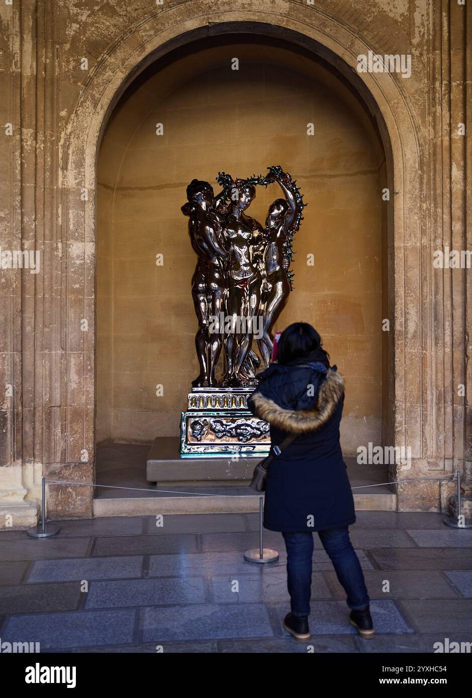 A woman photographs Jeff Koons' artwork 'Three Graces' in the courtyard ...