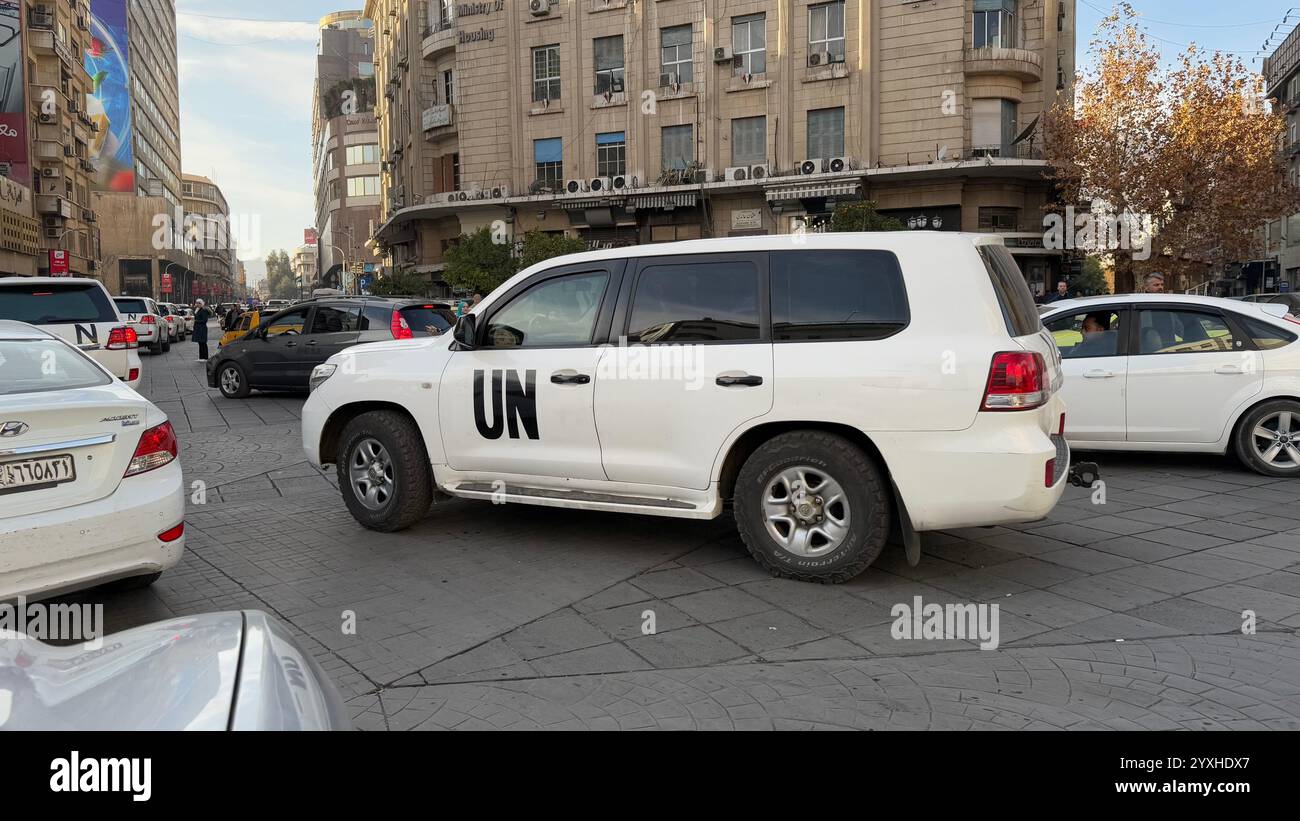 A convoy of United Nations vehicles passes through the streets of ...