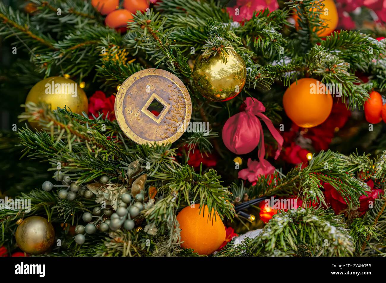 A decorated Christmas tree with Chinese-inspired ornaments, gold coins ...