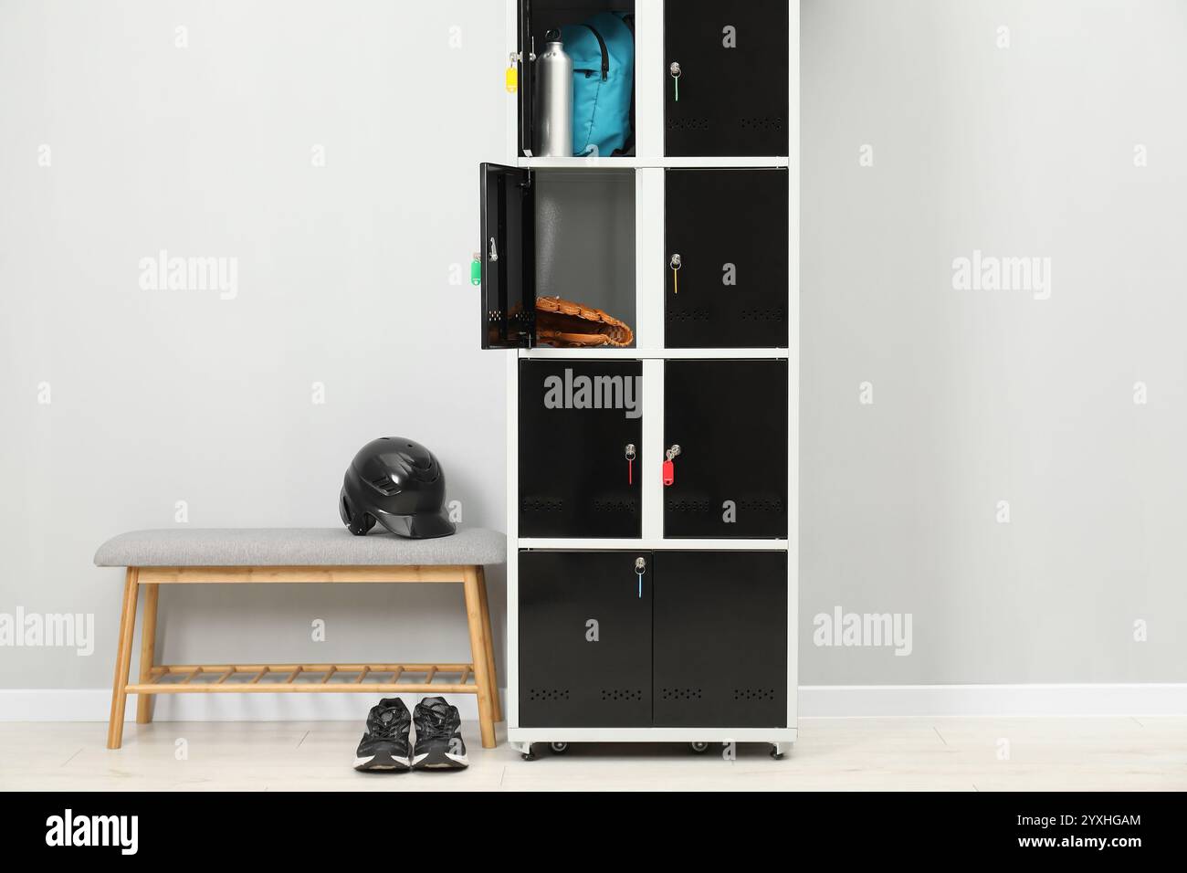 Lockers with personal belongings and bench in changing room at gym ...