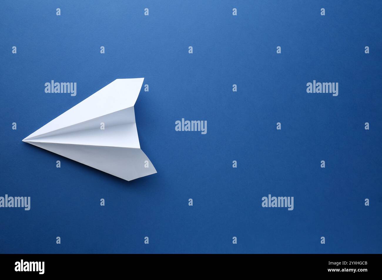 One handmade paper plane on blue background, top view. Space for text ...