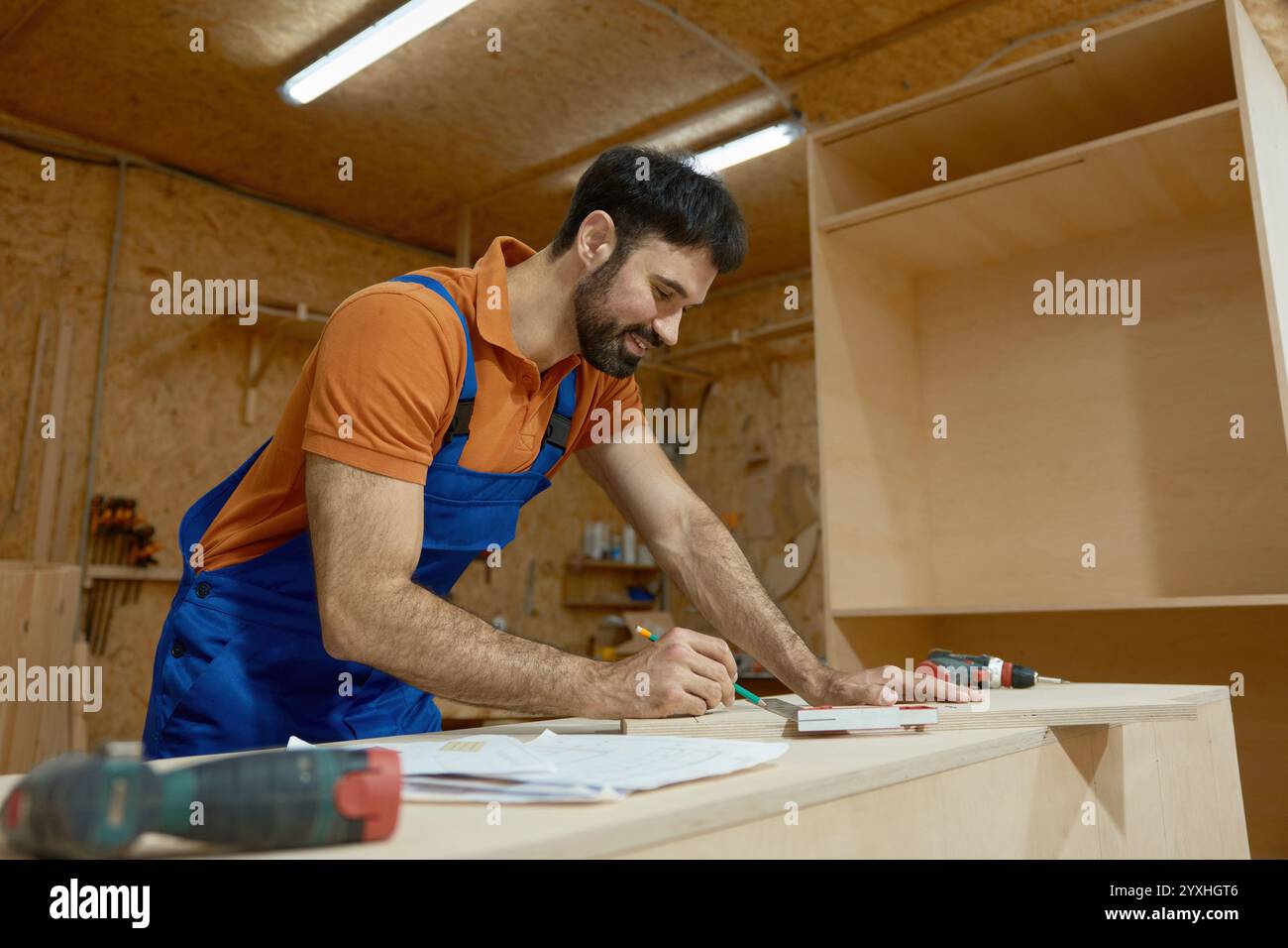 Carpenter measuring with ruler during furniture production process at ...