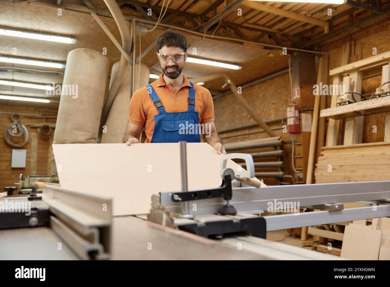 Male artisan worker holding and assembling pieces of wood using glue ...