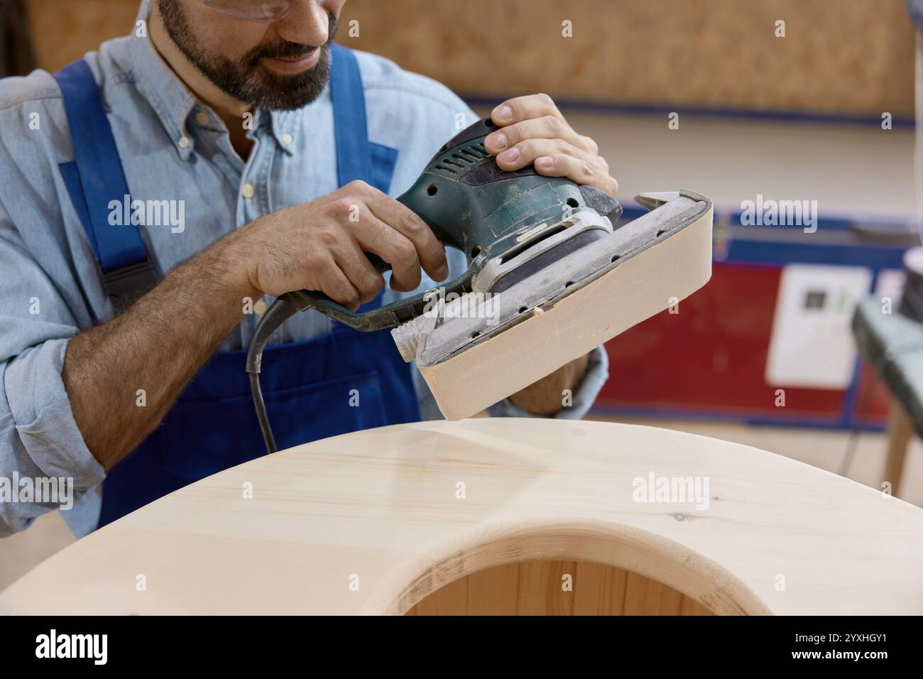 Woodworker using grinding machine for finishing wood construction Stock ...