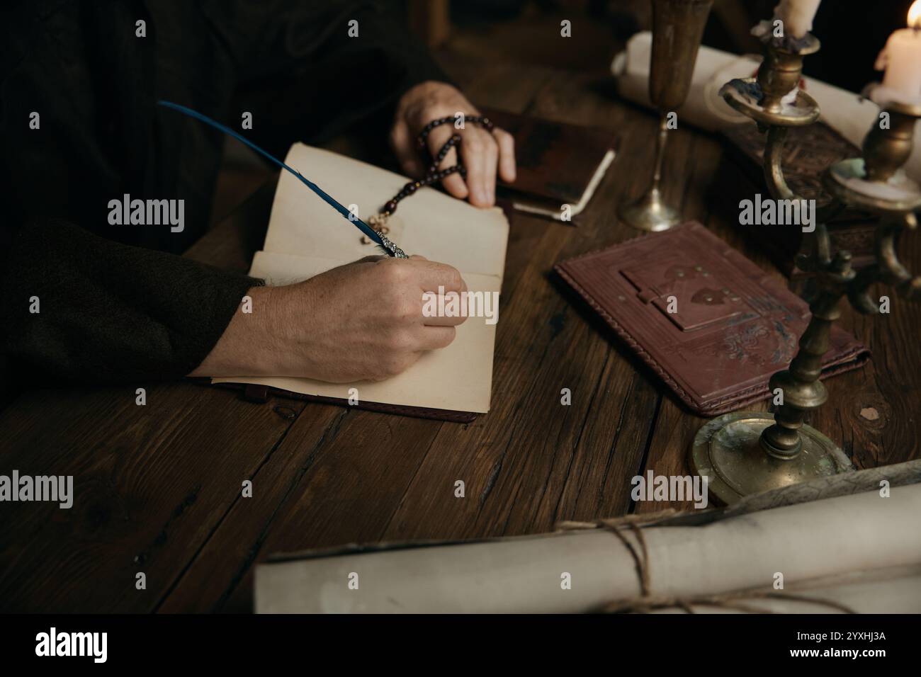 Crop shot of medieval monk chronicler writing ancient manuscript under ...