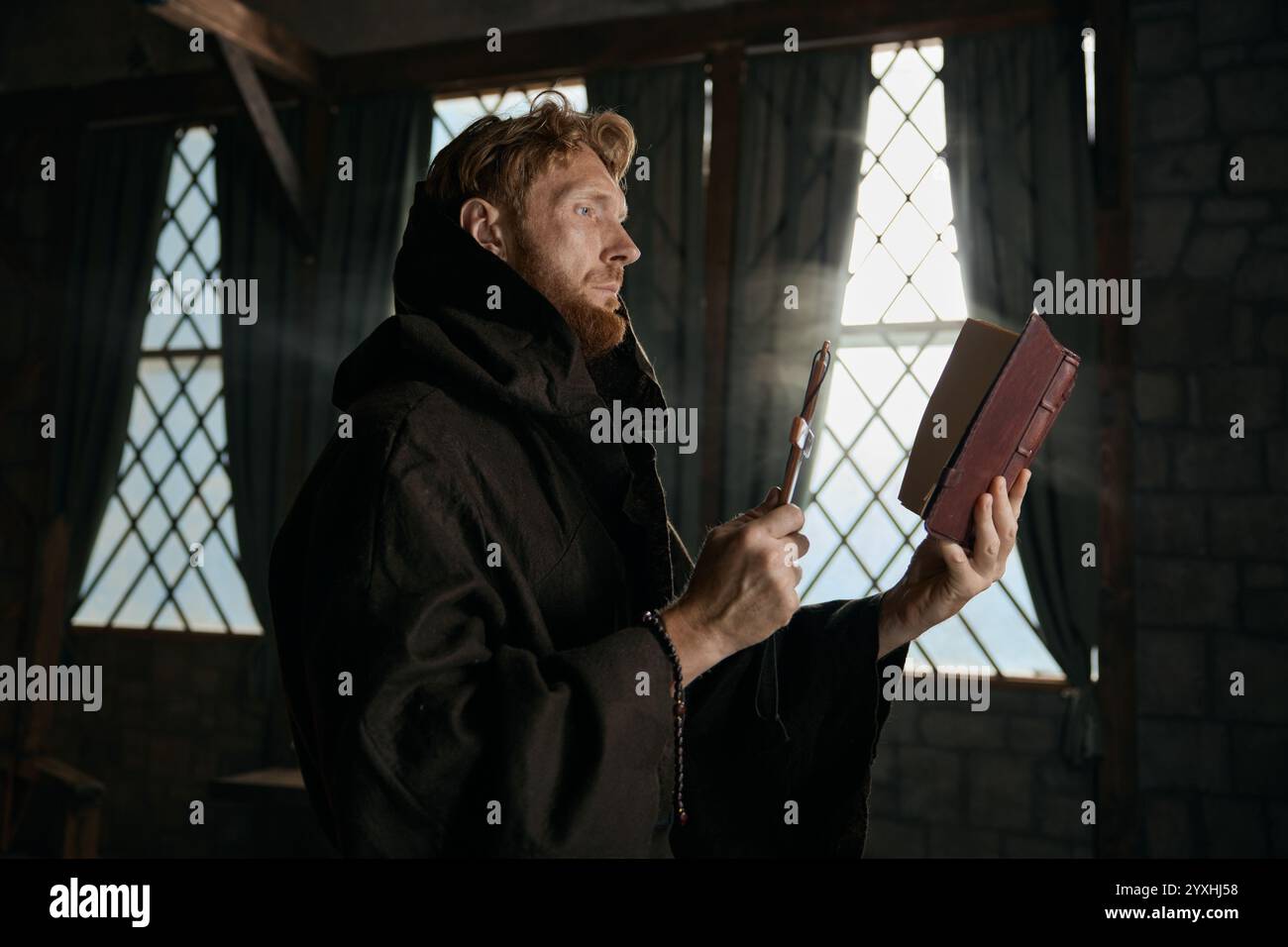 Medieval priest holding cross and holy bible performing exorcism rite ...