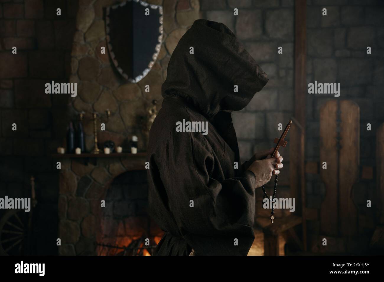 Faithful priest in robe hood praying with rosary beads and cross Stock ...