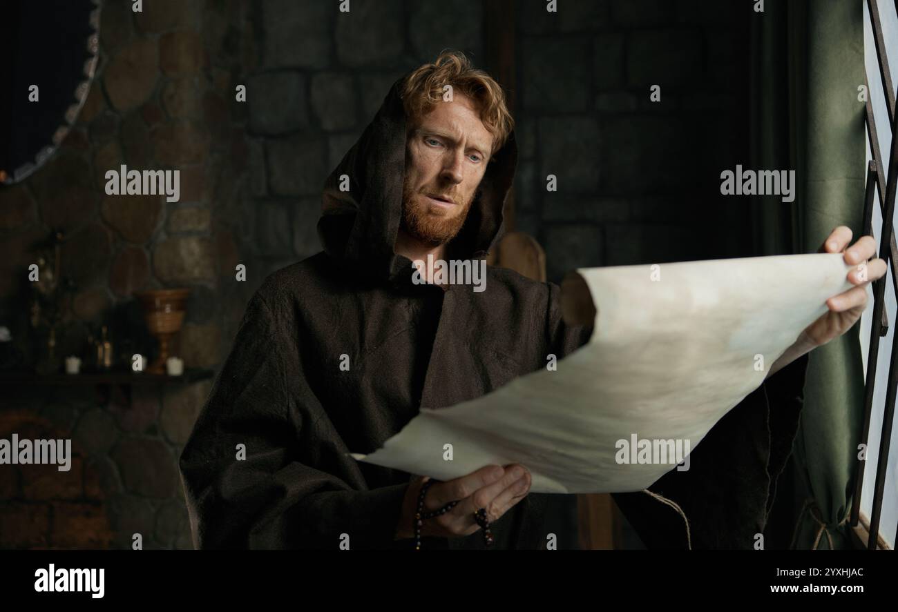 Medieval monk reading obsolete historical parchments and holy ...