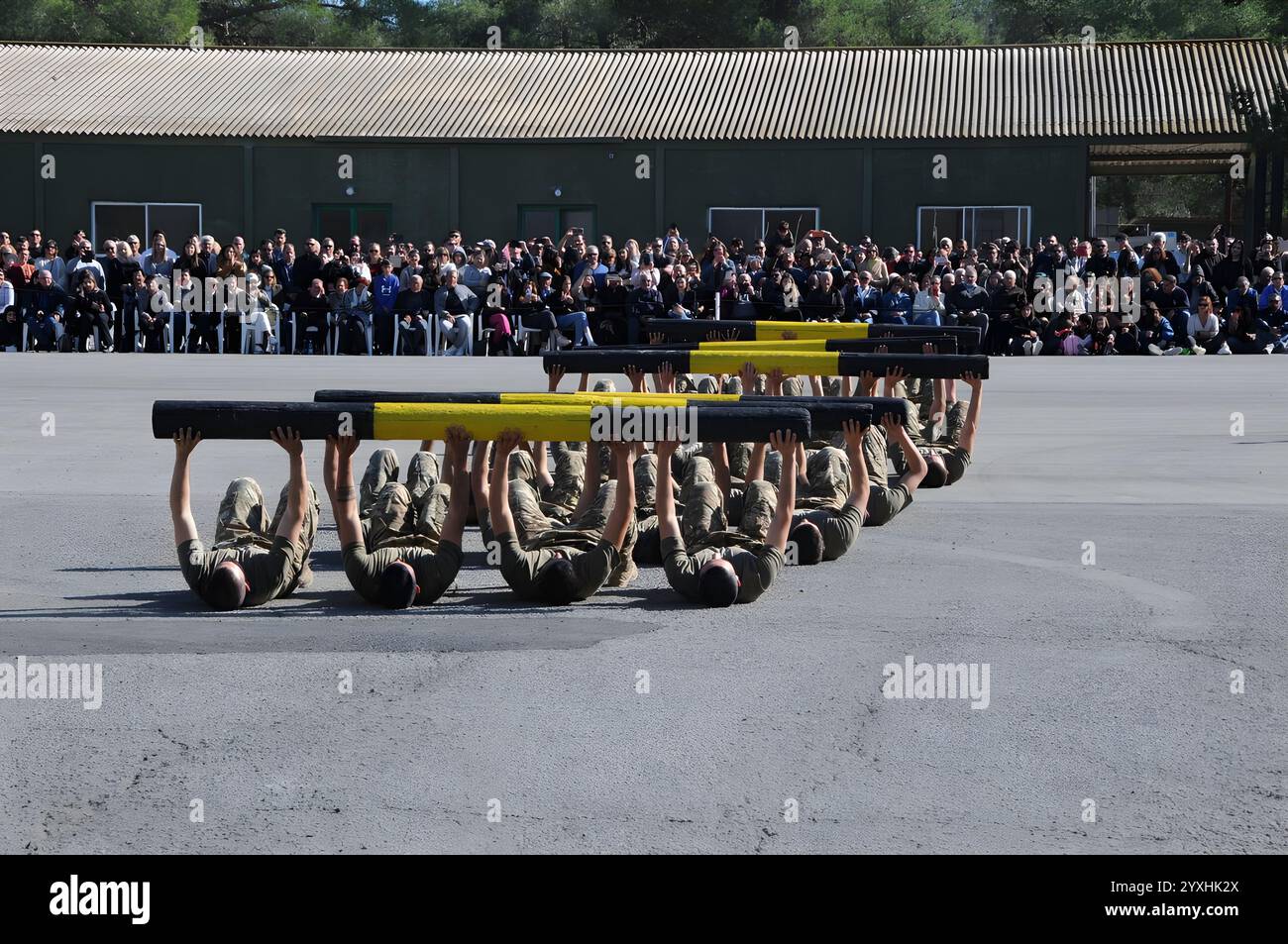A group of soldiers is lying on their backs performing a coordinated ...