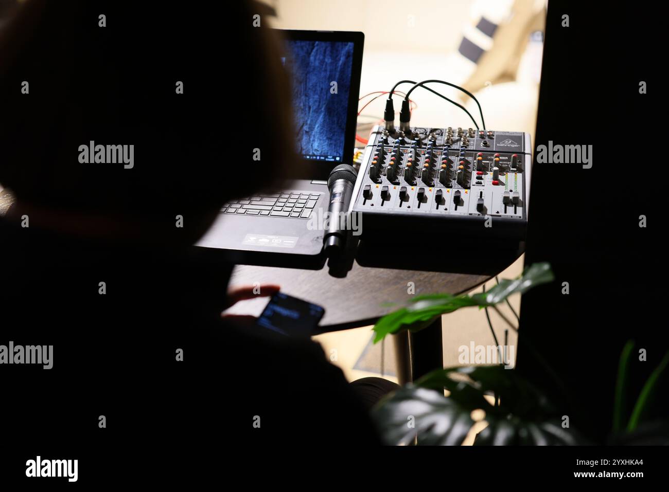 A DJ setup featuring a mixer and laptop situated in an engaging and ...