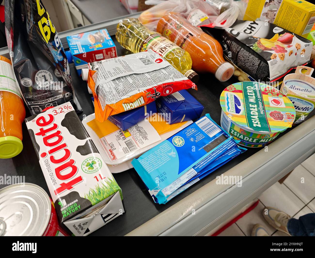 Variety of grocery products at store checkout with dairy snacks ...