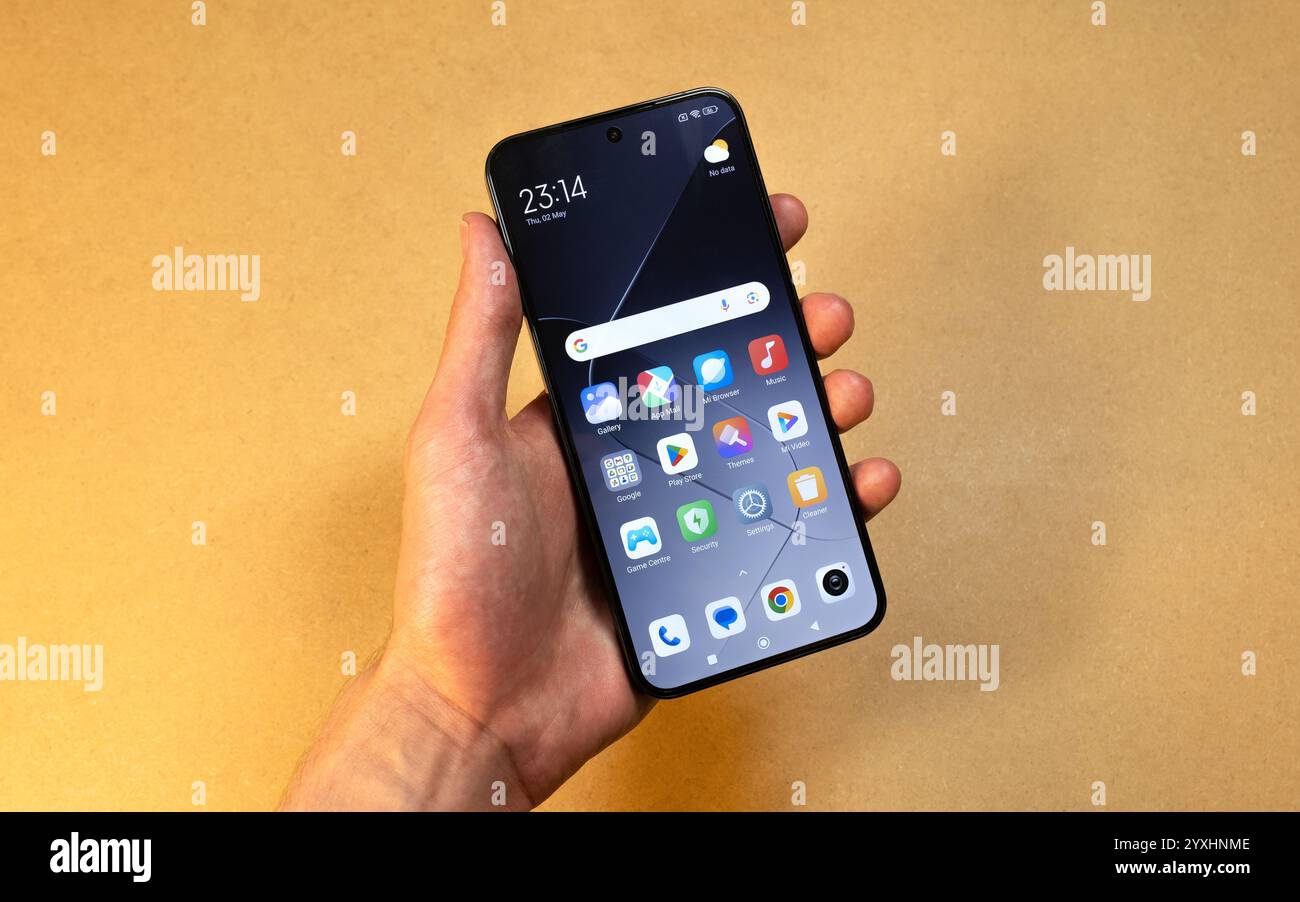 Man's hand holding a modern Xiaomi smartphone with home screen apps ...