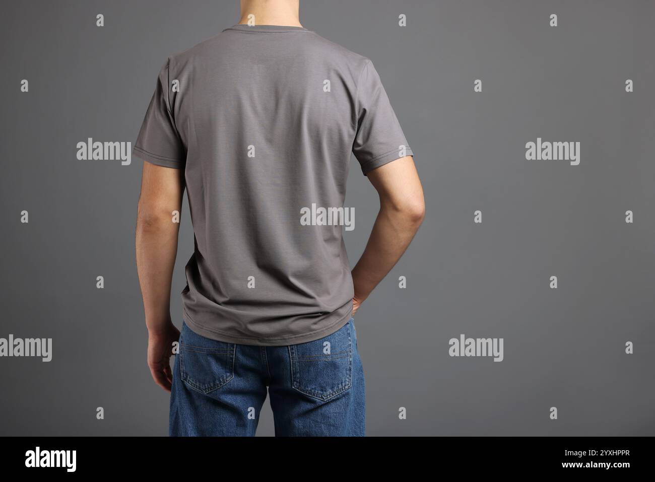 Man in stylish t-shirt on grey background, back view. Mockup for design ...